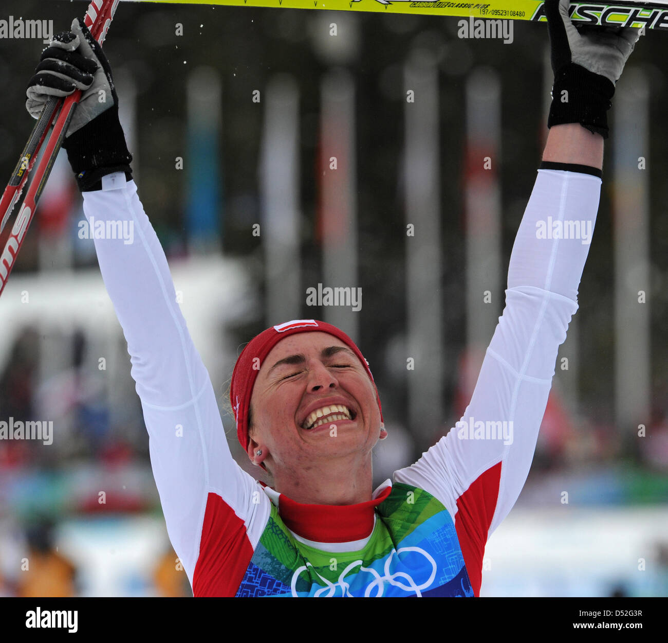 Justyna Kowalczyk of Poland raises her arms in joy as she crosses the ...