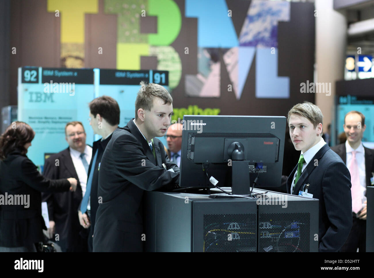 Visitors check out the 'IBM' stand at the computing and information ...
