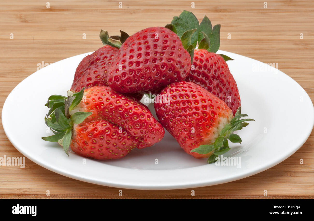 Group of fresh strawberries on white plate Stock Photo - Alamy
