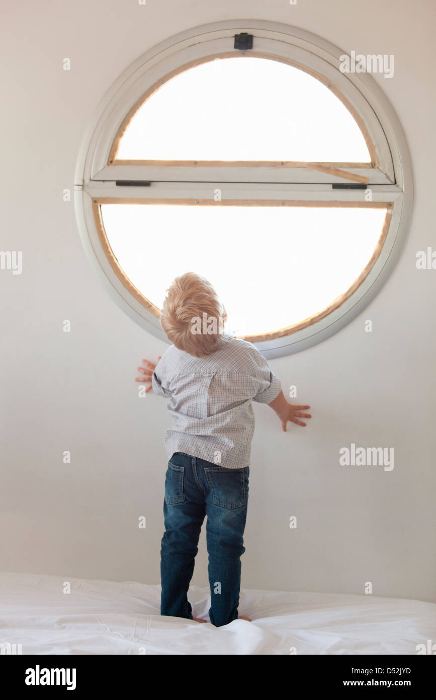 Little boy looking out window, rear view Stock Photo - Alamy