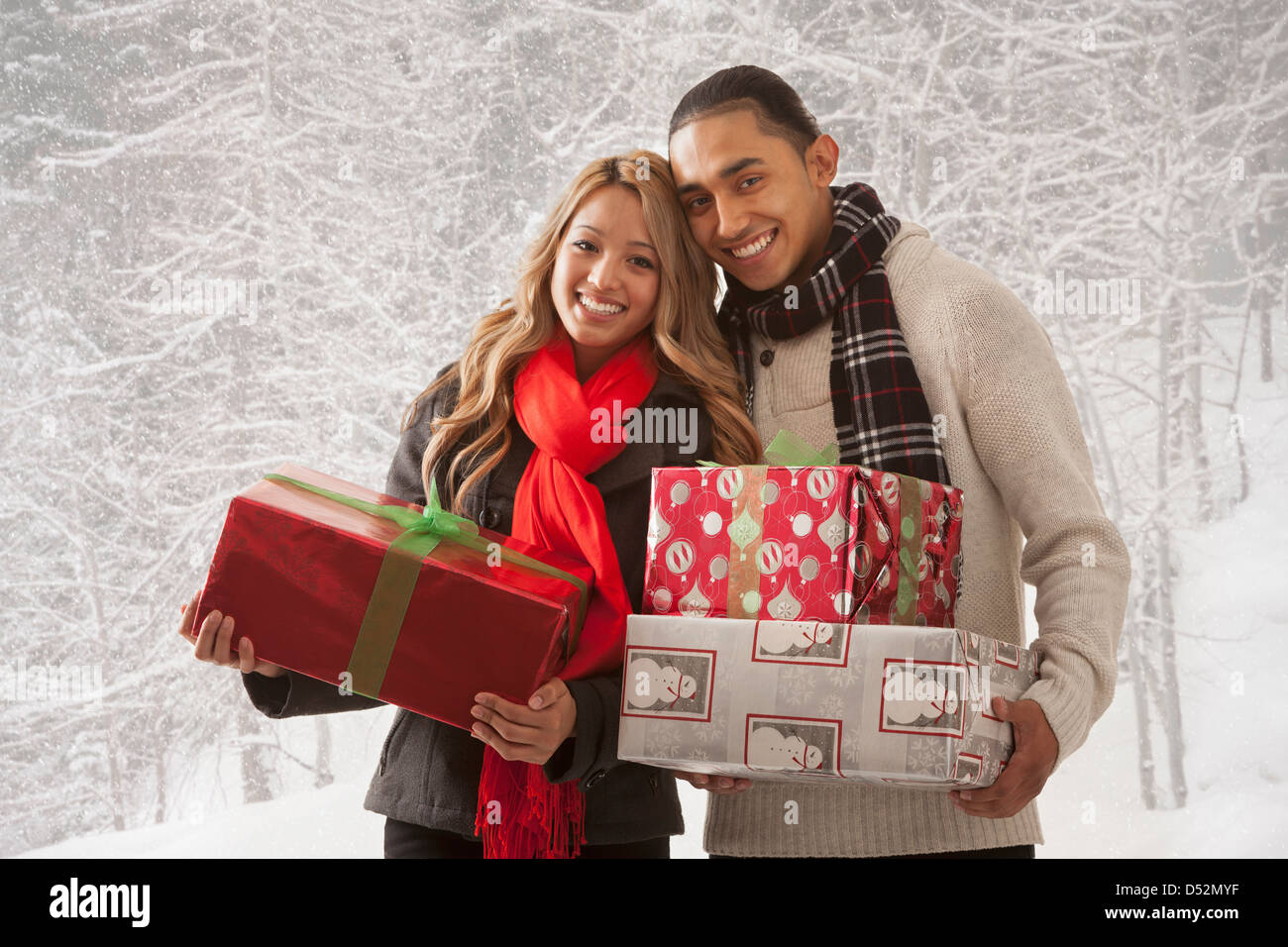 Couple holding presents in snow Stock Photo - Alamy