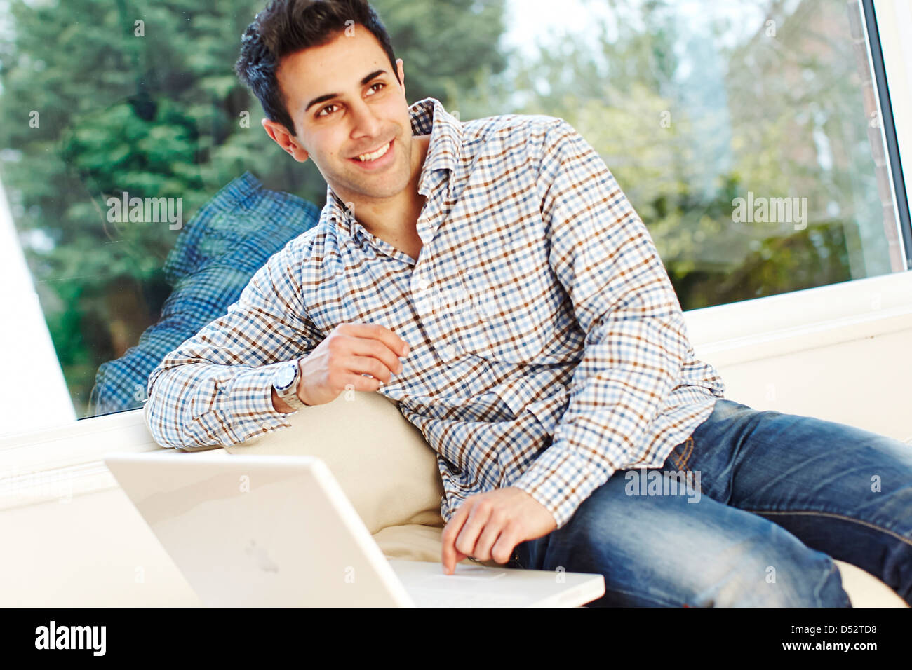 Man relaxing using laptop Stock Photo - Alamy