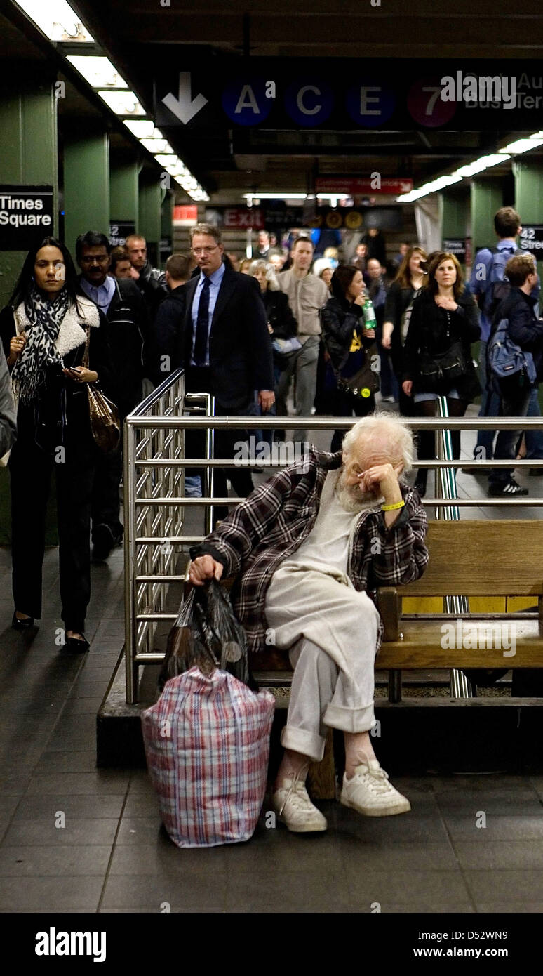 New York City, USA, a homeless man on a bench in the subway station ...