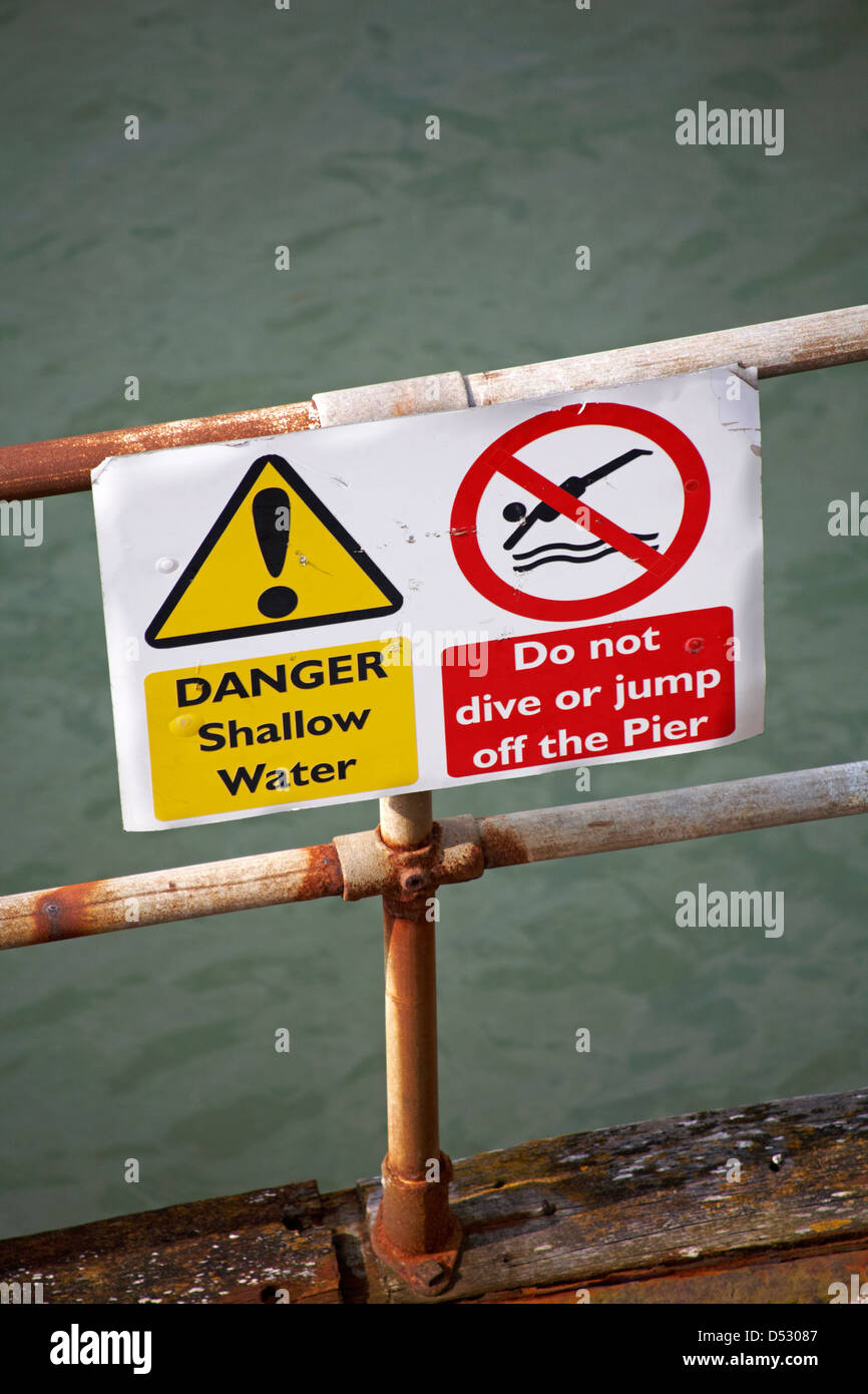 Danger shallow water do not dive or jump off of the pier signs on ...