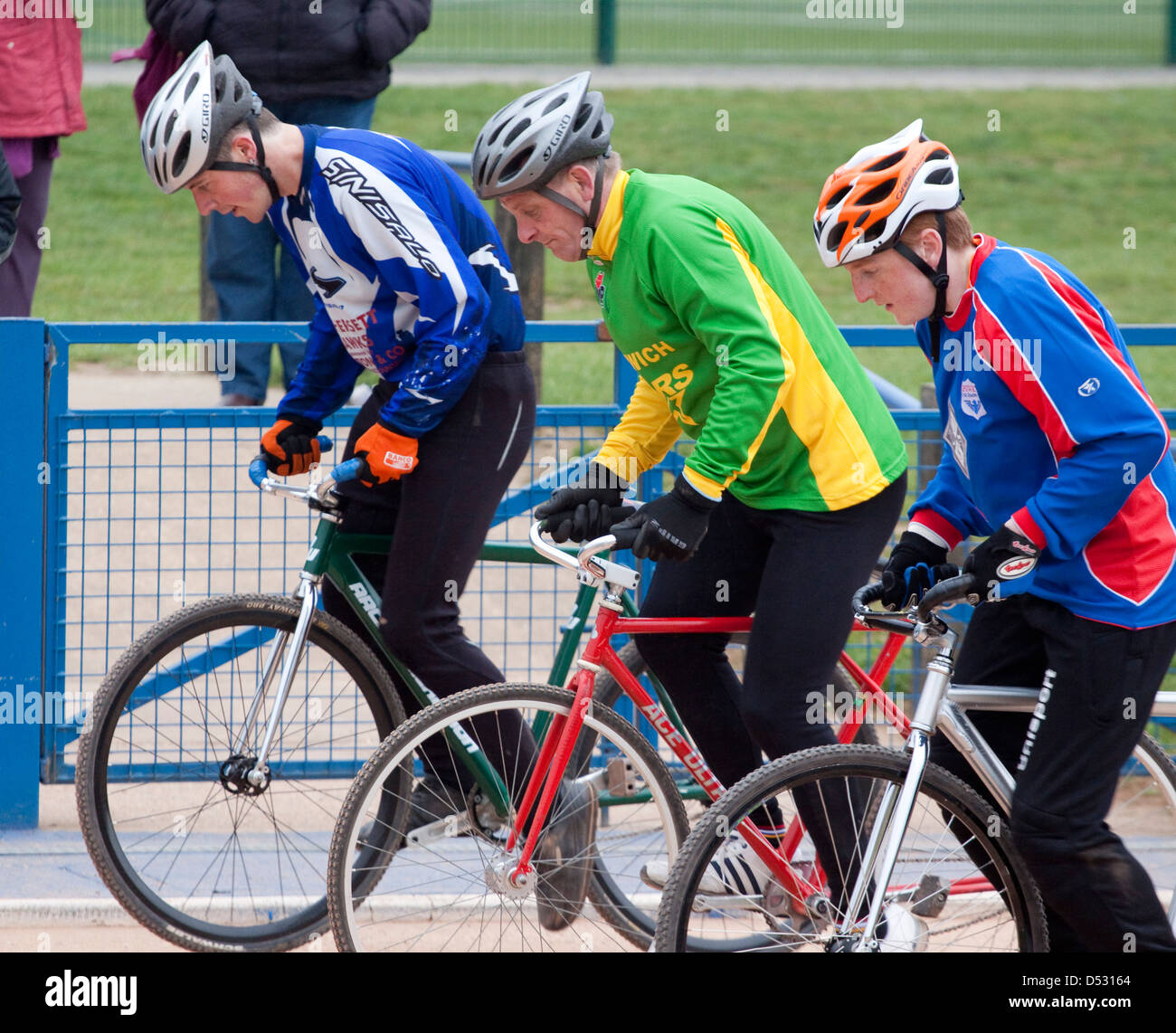 Three competitors out of the saddle at the start of a bicycle speedway ...