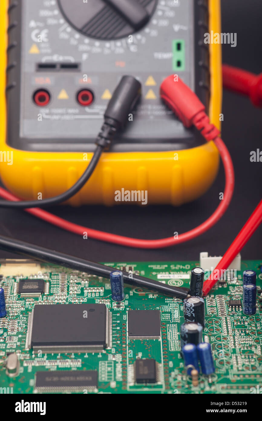 Electronic circuit and polimeter in black background Stock Photo - Alamy
