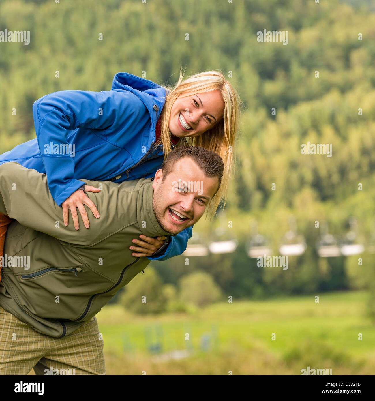 Young smiling couple having fun piggyback riding in the nature Stock ...