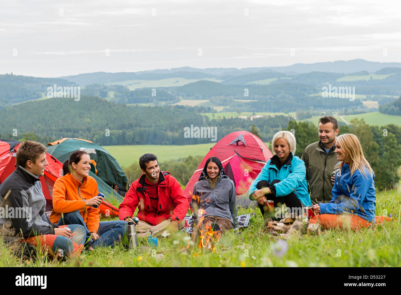 Smiling young people enjoying nature beside tents and scenic view Stock ...