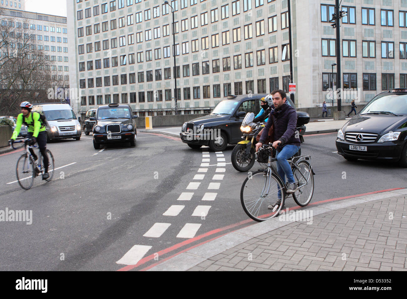 cyclists and traffic waiting to enter a roundabout in London, England ...