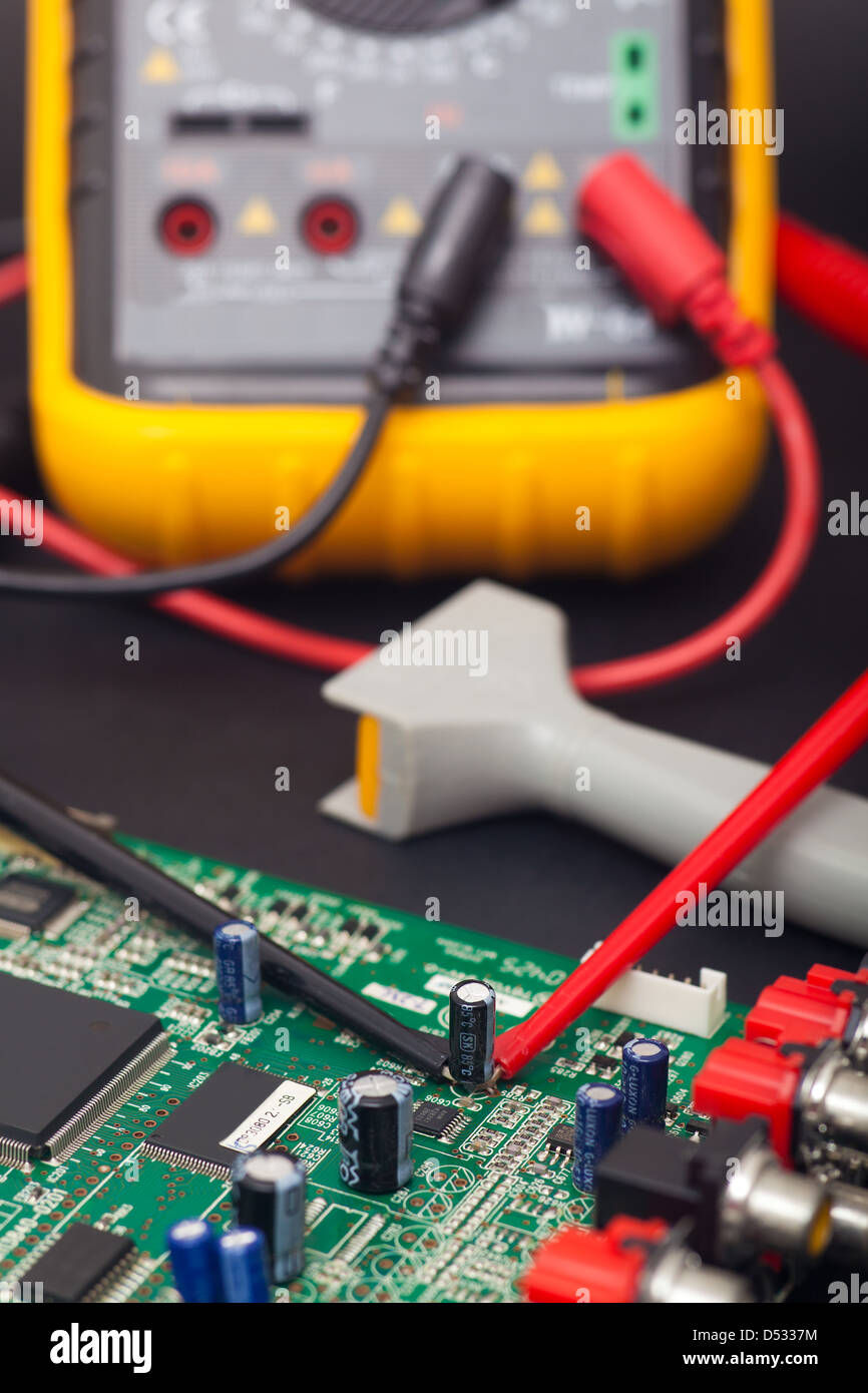 Electronic circuit and polimeter in black background Stock Photo - Alamy