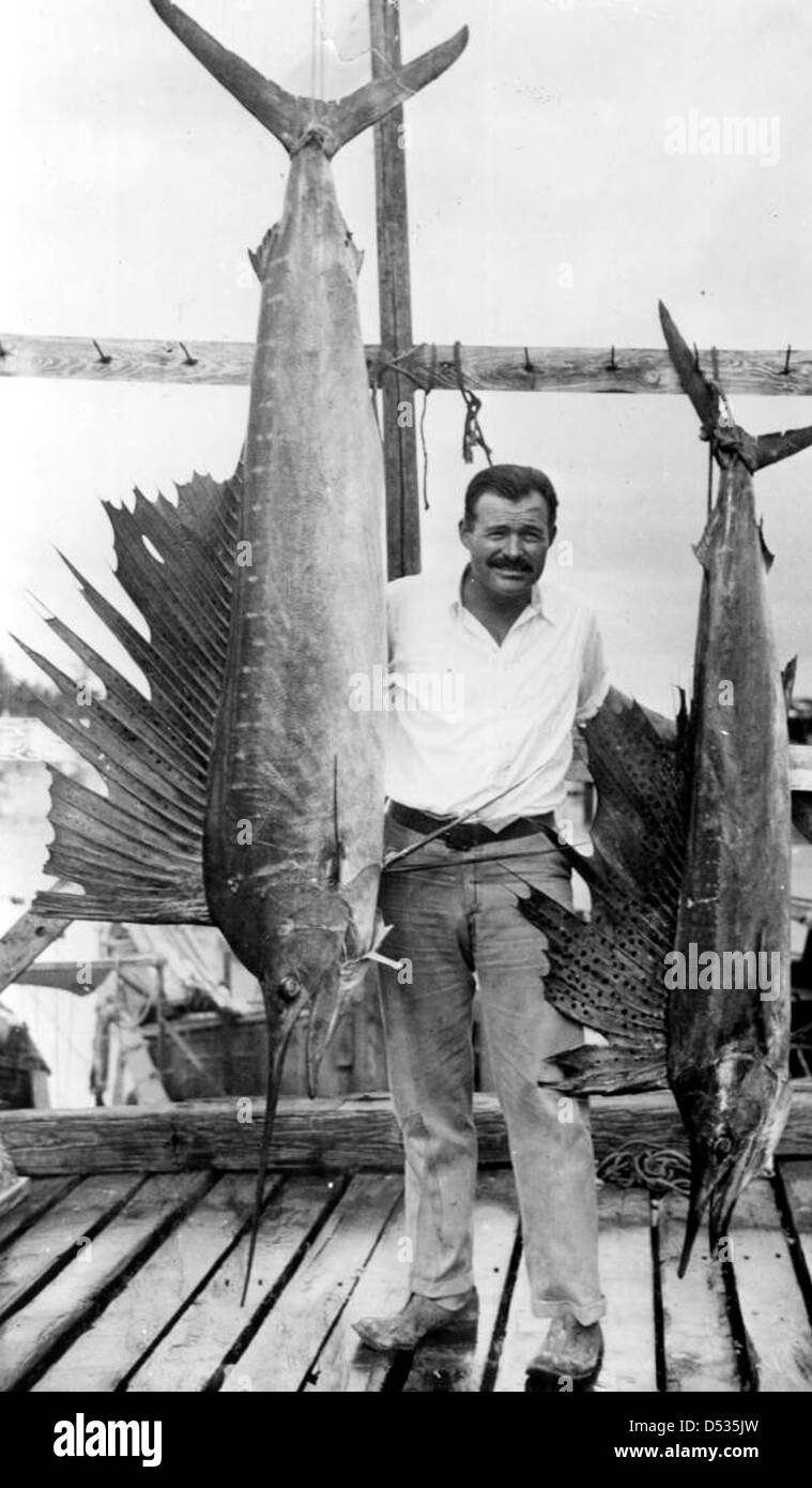 Ernest Hemingway poses with a sailfish in Key West, Florida, reflecting ...
