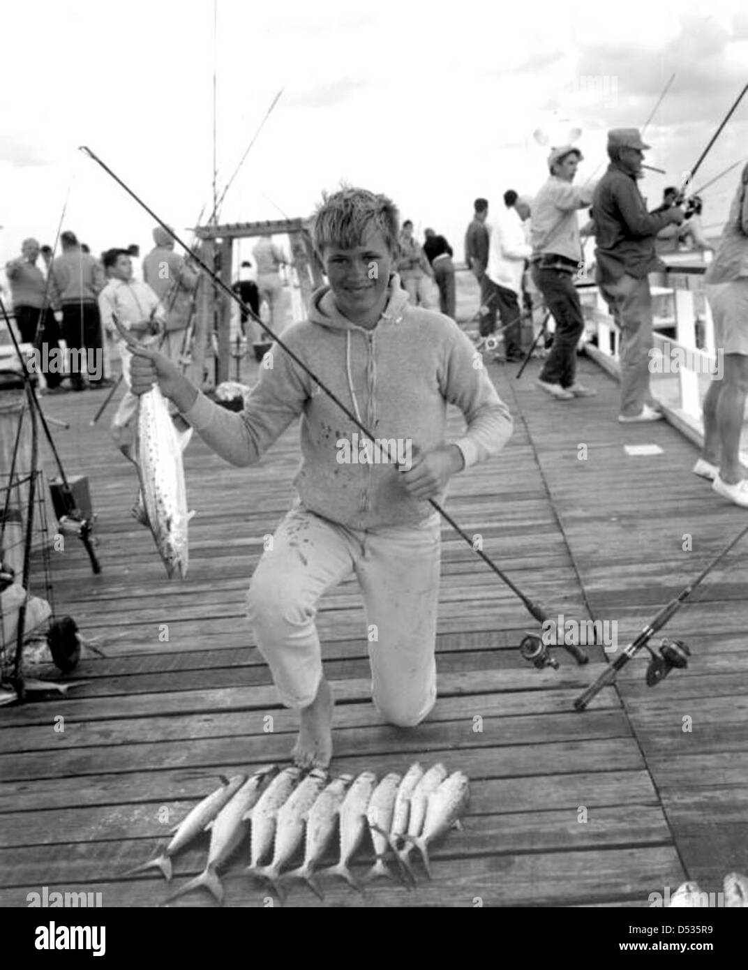 14-year-old Keith Berg proudly holds up a catch of fish on the pier at ...