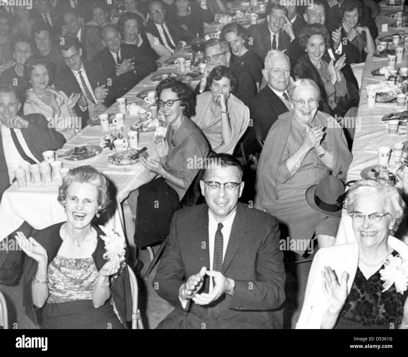 A photograph of people laughing at a dinner, captured during a World ...