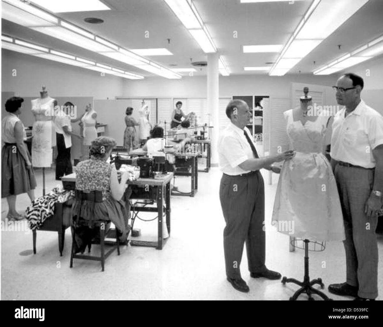 Alex Schneidman and Luther Powell inspect a sample dress at the Alix ...