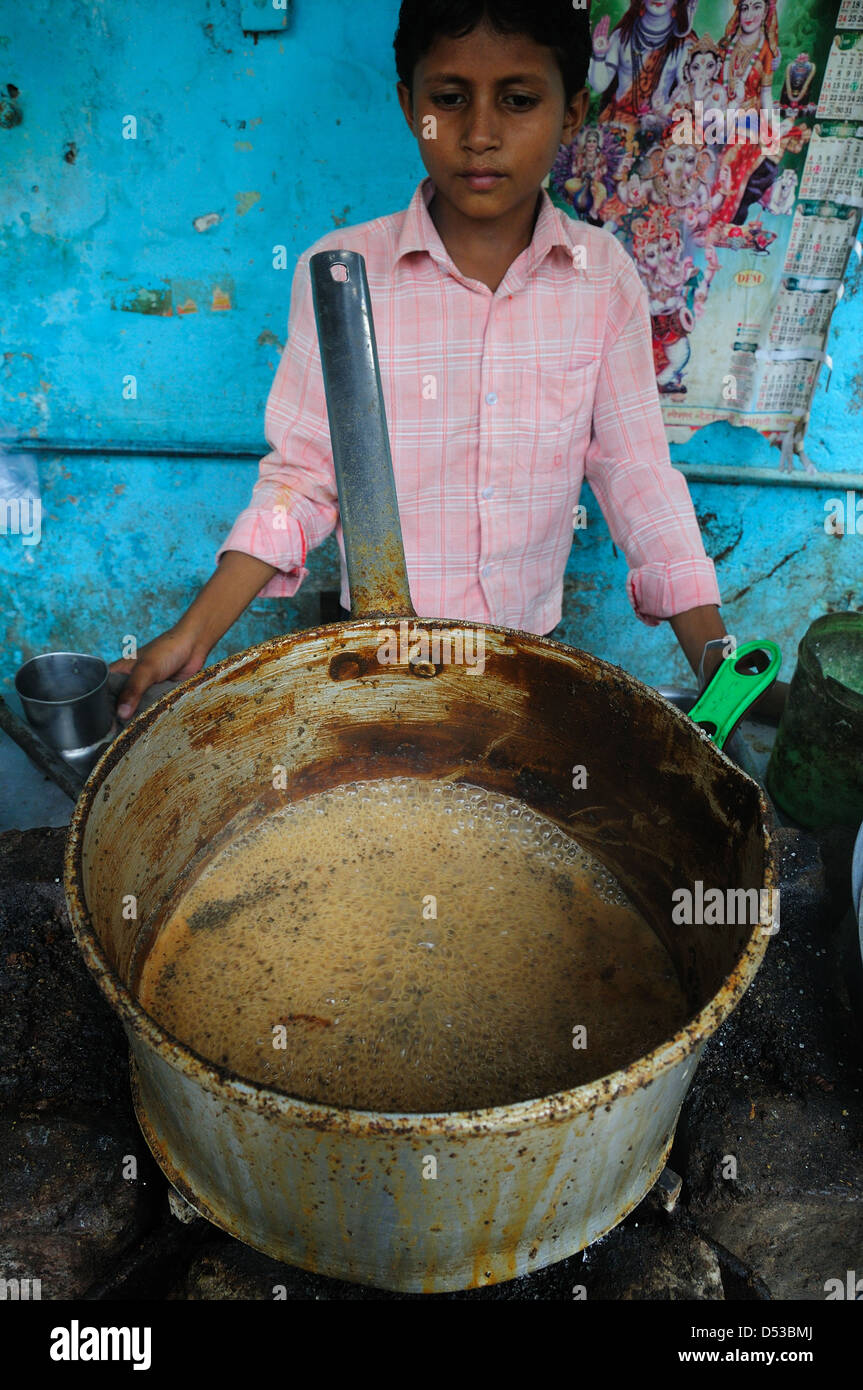 Young boy making tea on the back street Stock Photo - Alamy