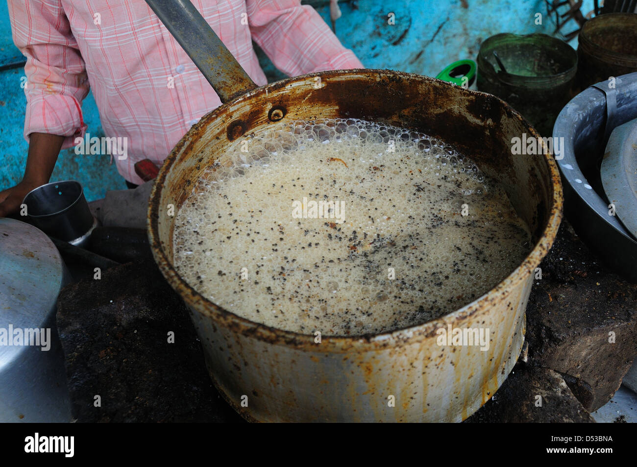 Young boy making tea on the back street Stock Photo - Alamy