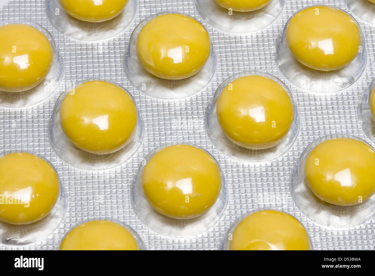 Yellow pills isolated on white background Stock Photo - Alamy