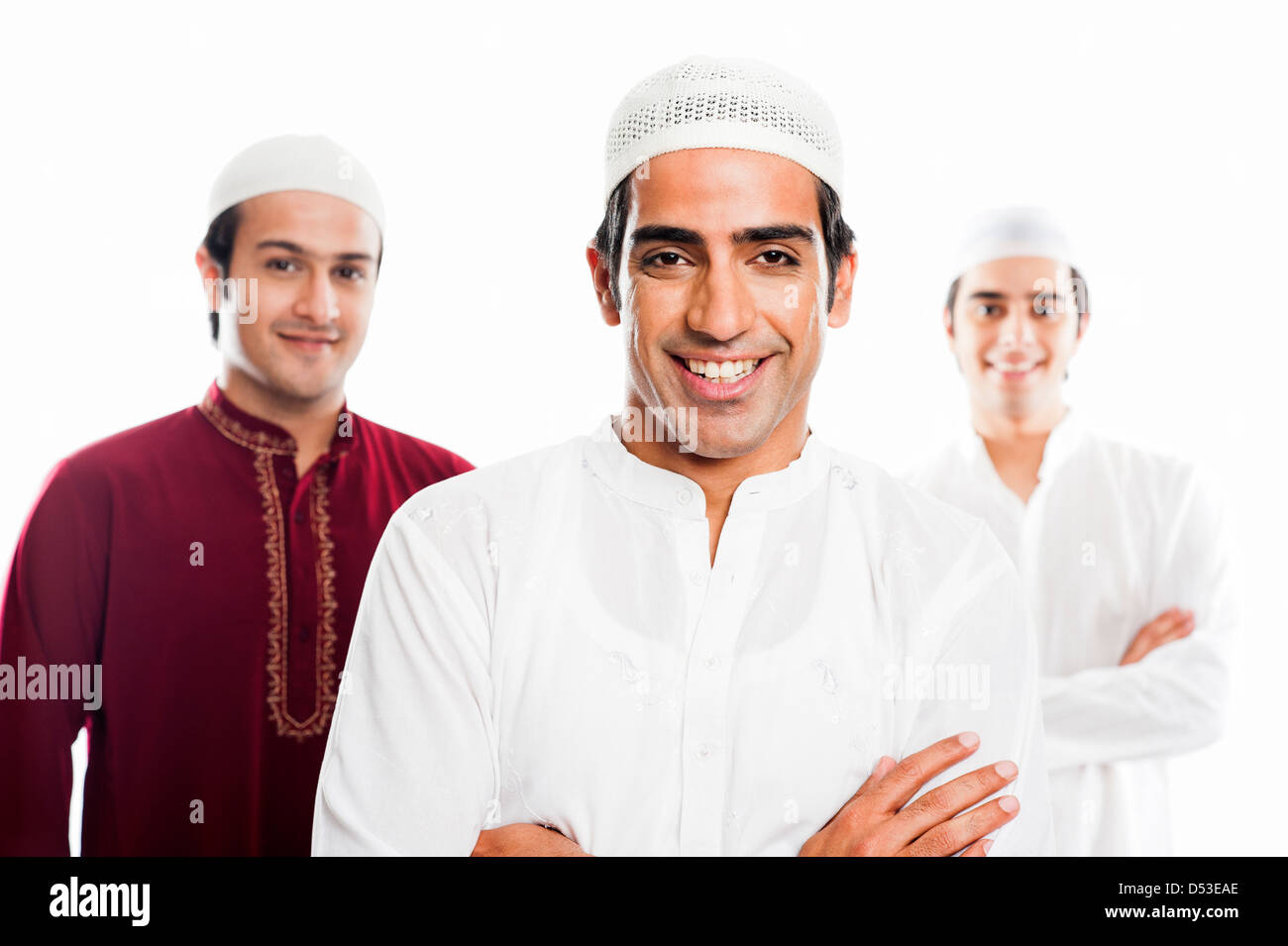 Portrait of a man smiling with his friends in the background during Eid ...
