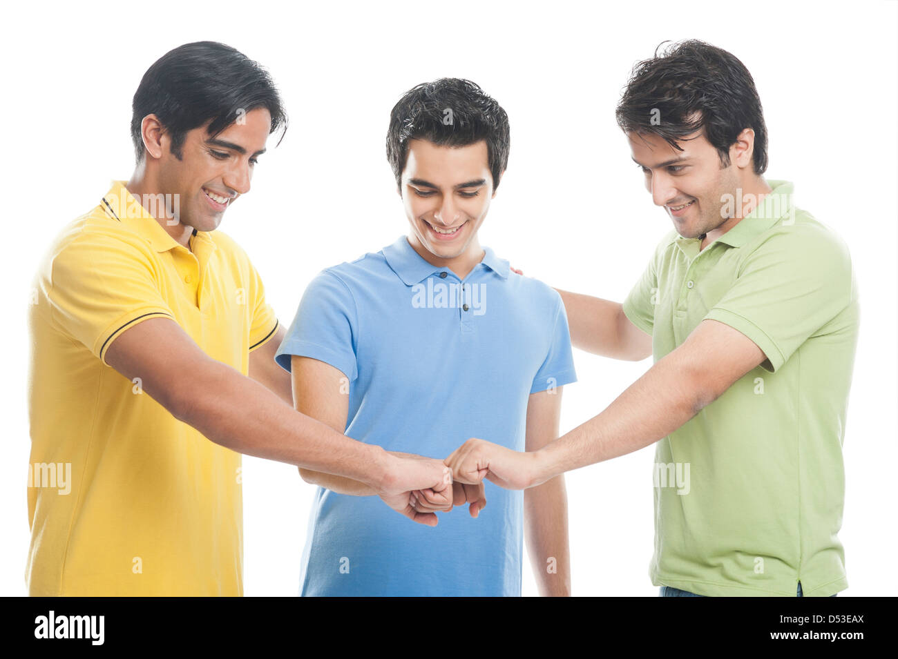 Three friends joining their hands and smiling Stock Photo - Alamy
