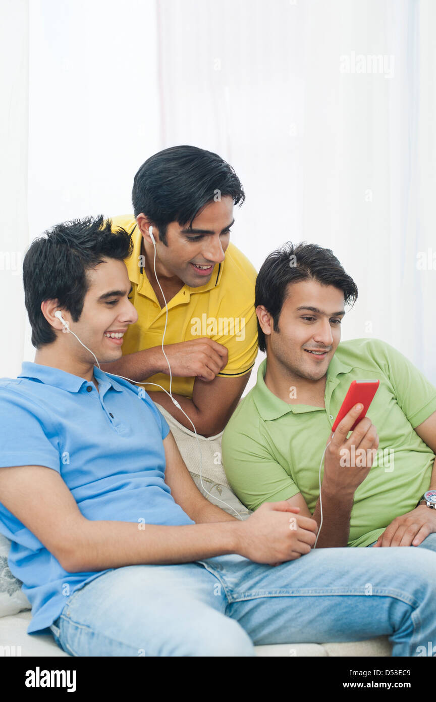 Friends listening to music with an MP3 player at home Stock Photo - Alamy