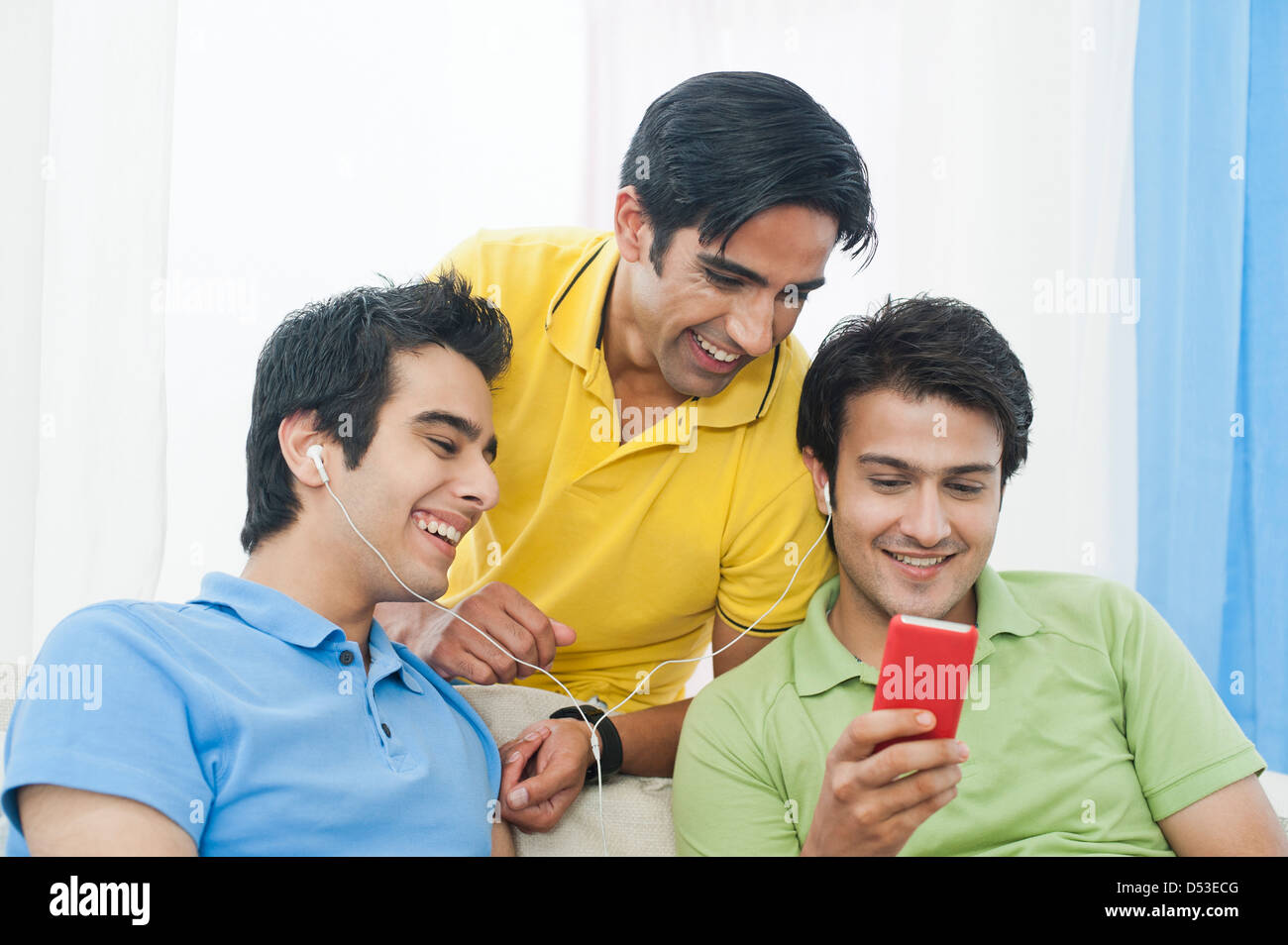 Friends listening to music with an MP3 player at home Stock Photo - Alamy