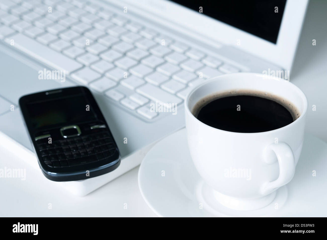 Modern laptop with mobile phone and cup of coffee Stock Photo - Alamy