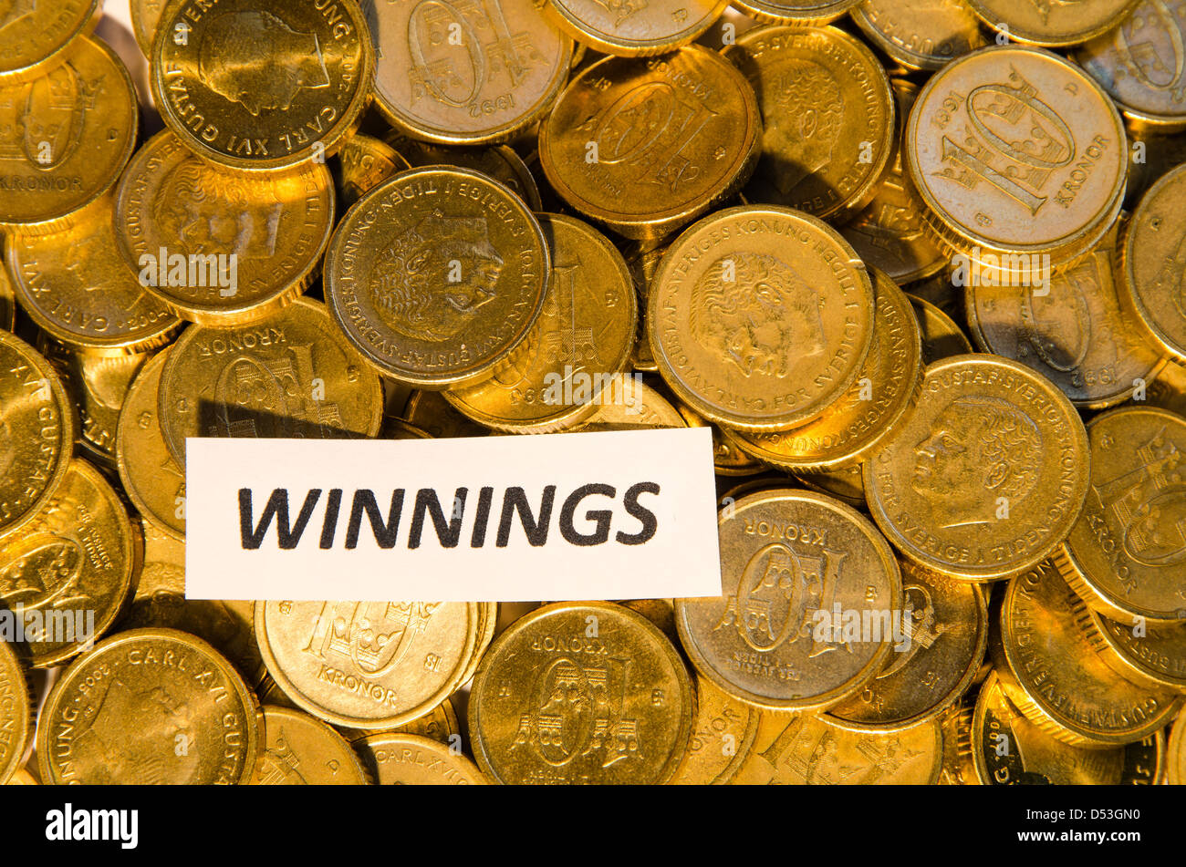 Stack of golden coins with a sign showing Winnings Stock Photo - Alamy