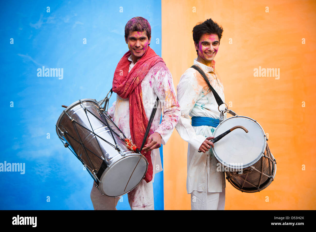 Portrait of two friends celebrating Holi with playing dhol Stock Photo ...