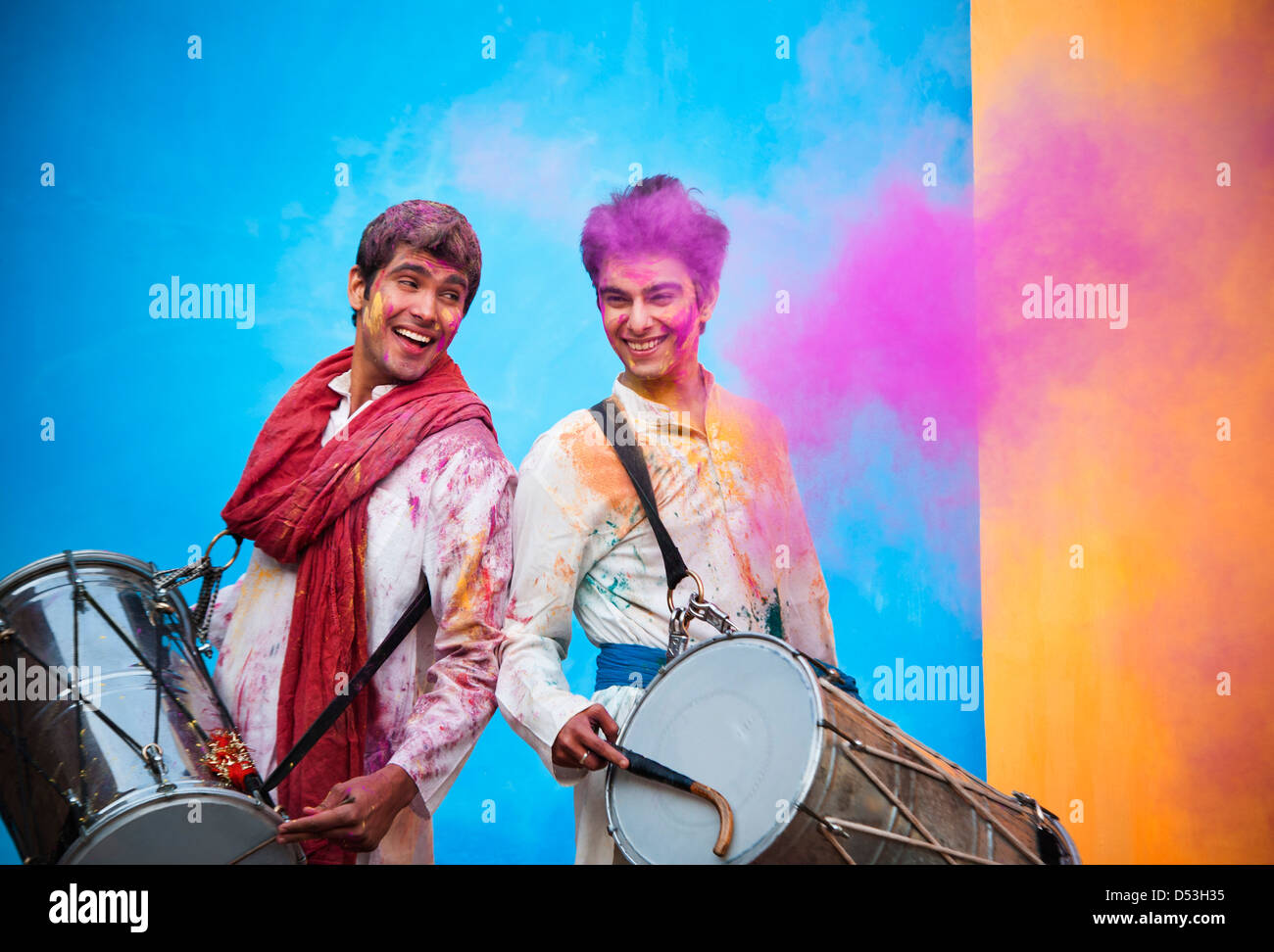 Two friends celebrating Holi with playing dhol Stock Photo - Alamy