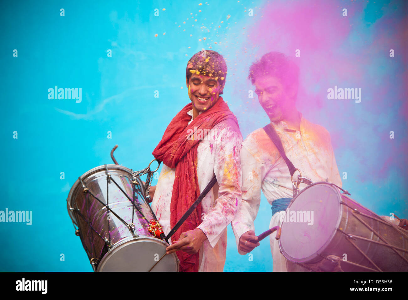 Two friends celebrating Holi with playing dhol Stock Photo - Alamy