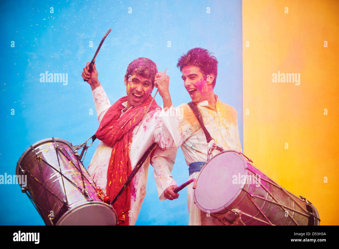 Two friends celebrating Holi with playing dhol Stock Photo - Alamy