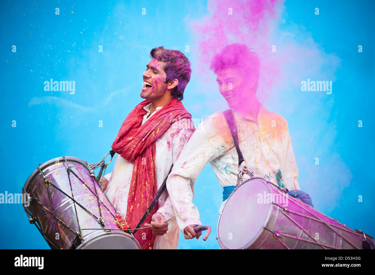 Two friends celebrating Holi with playing dhol Stock Photo - Alamy
