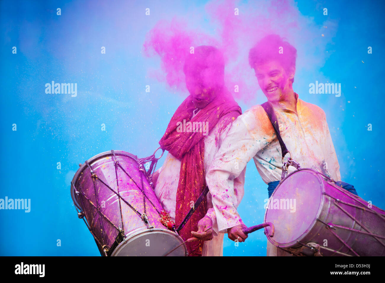 Two friends celebrating Holi with playing dhol Stock Photo - Alamy