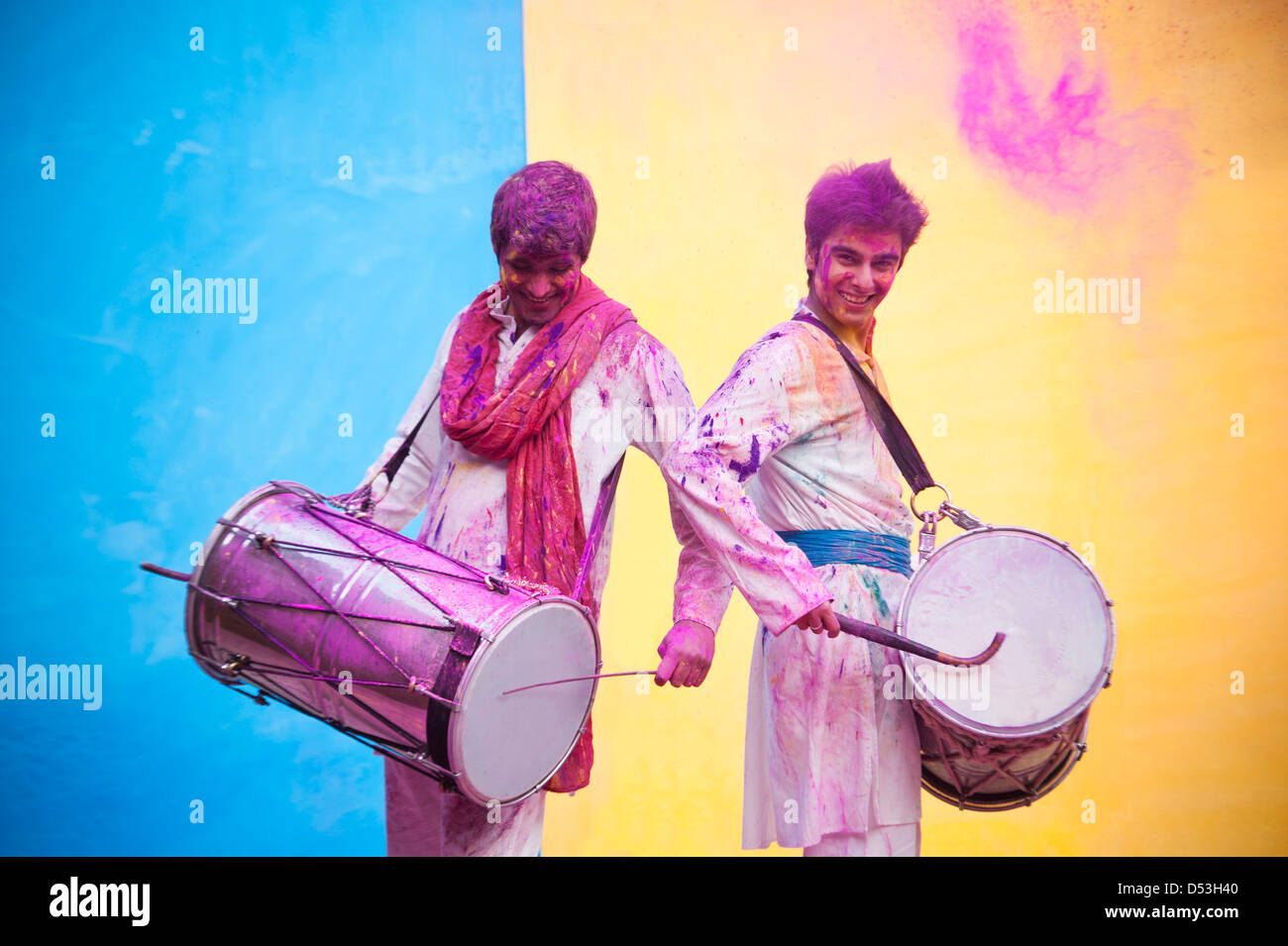 Two friends celebrating Holi with playing dhol Stock Photo - Alamy