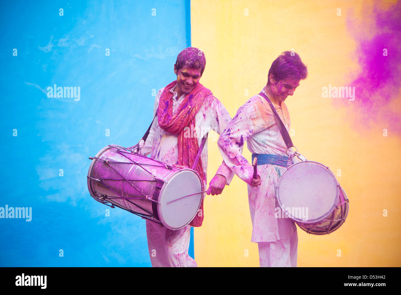 Two friends celebrating Holi with playing dhol Stock Photo - Alamy