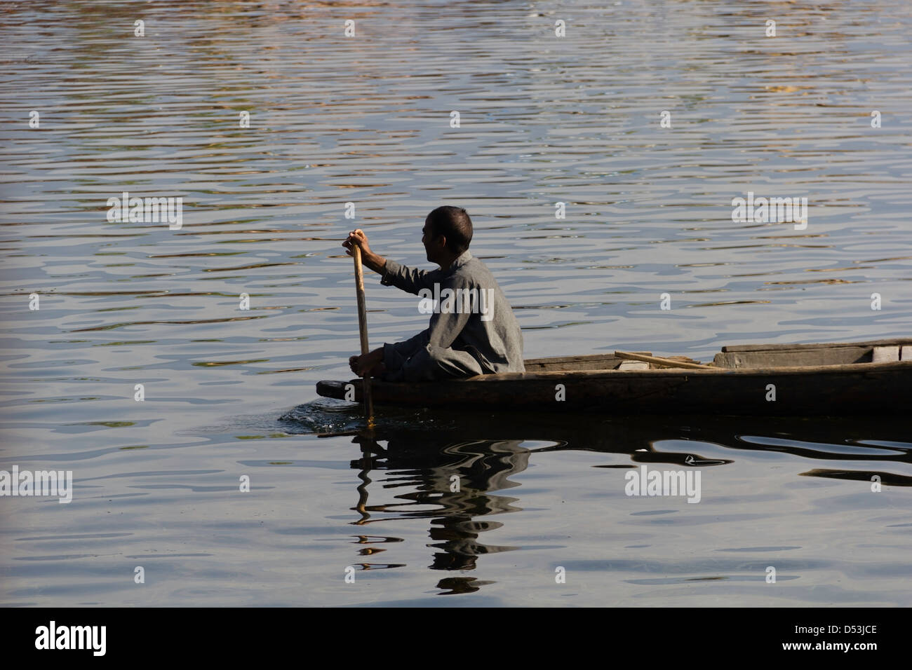 Splashing in the water caused due to Kashmiri man rowing a small wooden ...