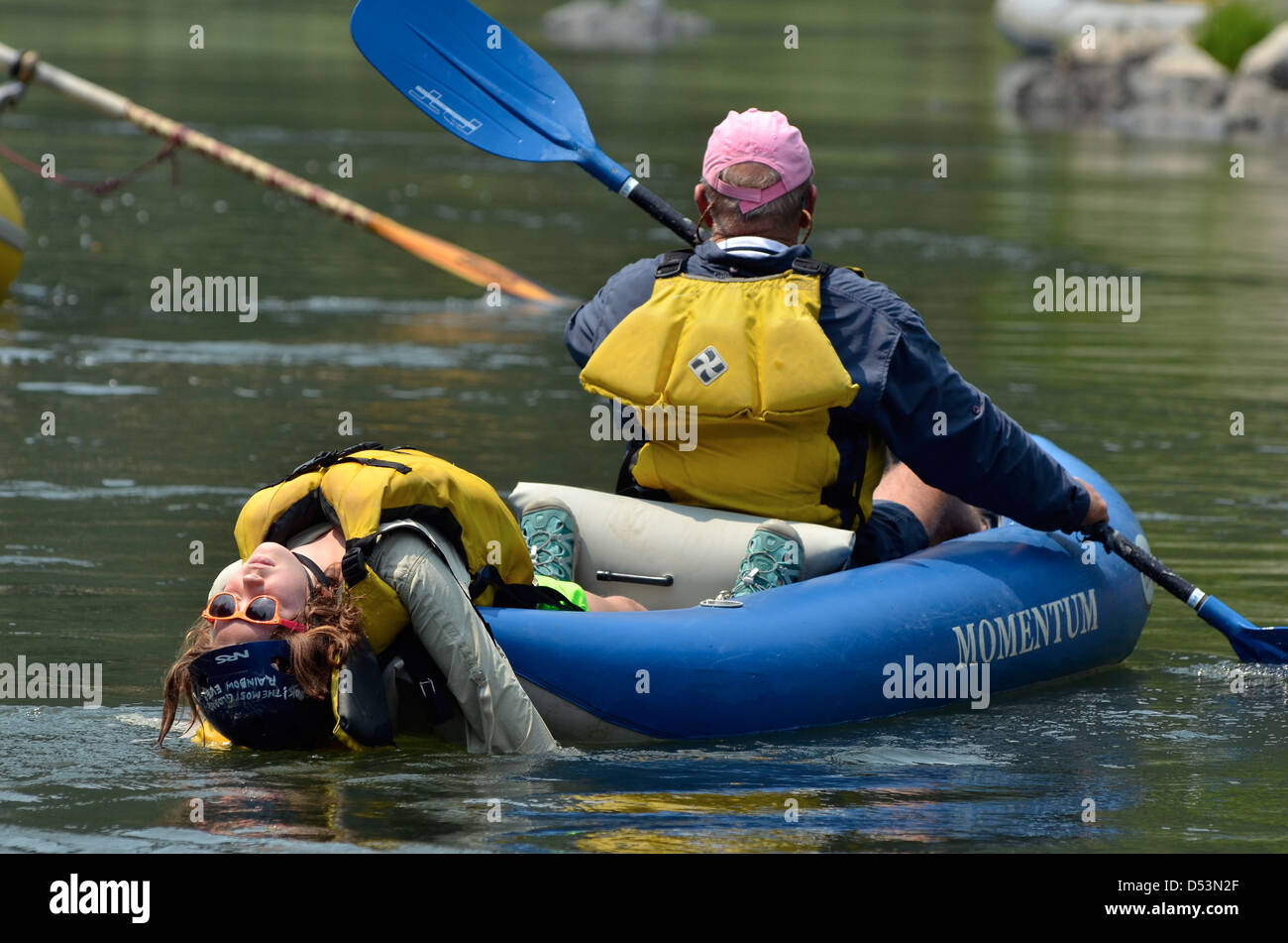 Girl asleep in the back of an inflatable kayak on a trip down Oregon's ...