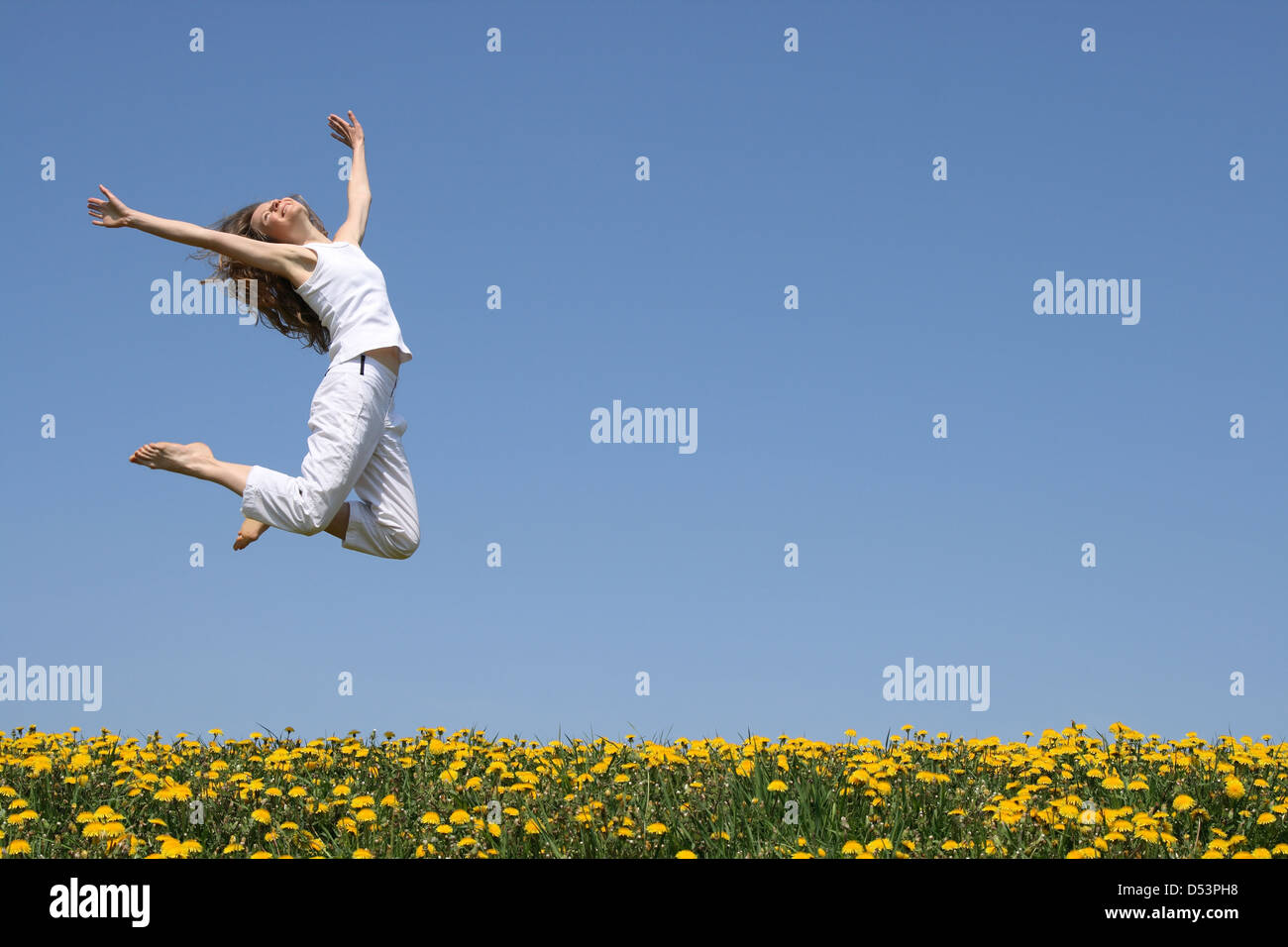 Beautiful smiling young woman in a happy jump Stock Photo - Alamy