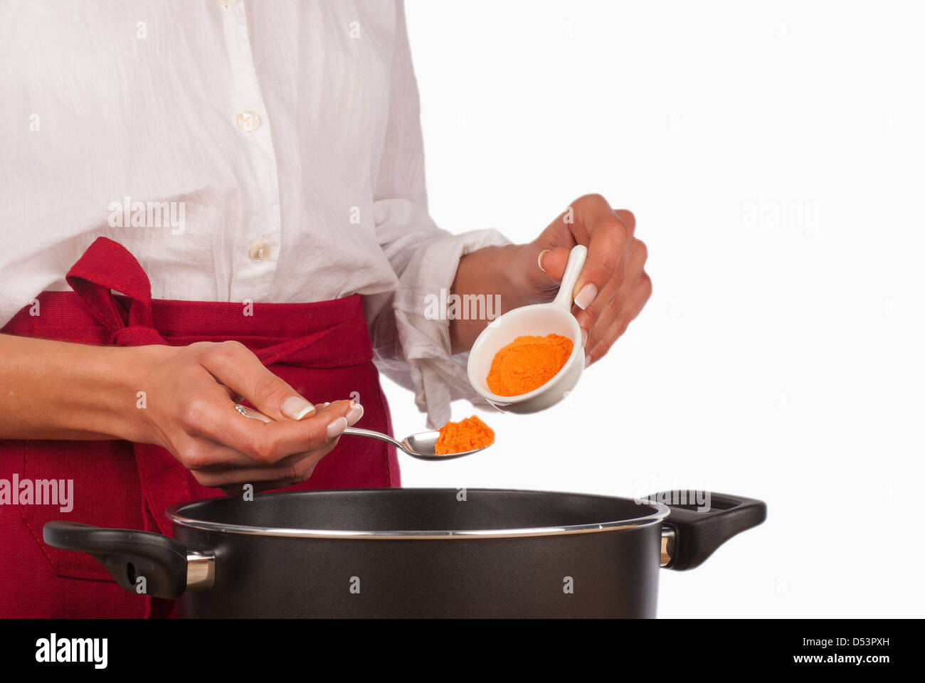 Female hands adding curry powder to a pot Stock Photo - Alamy