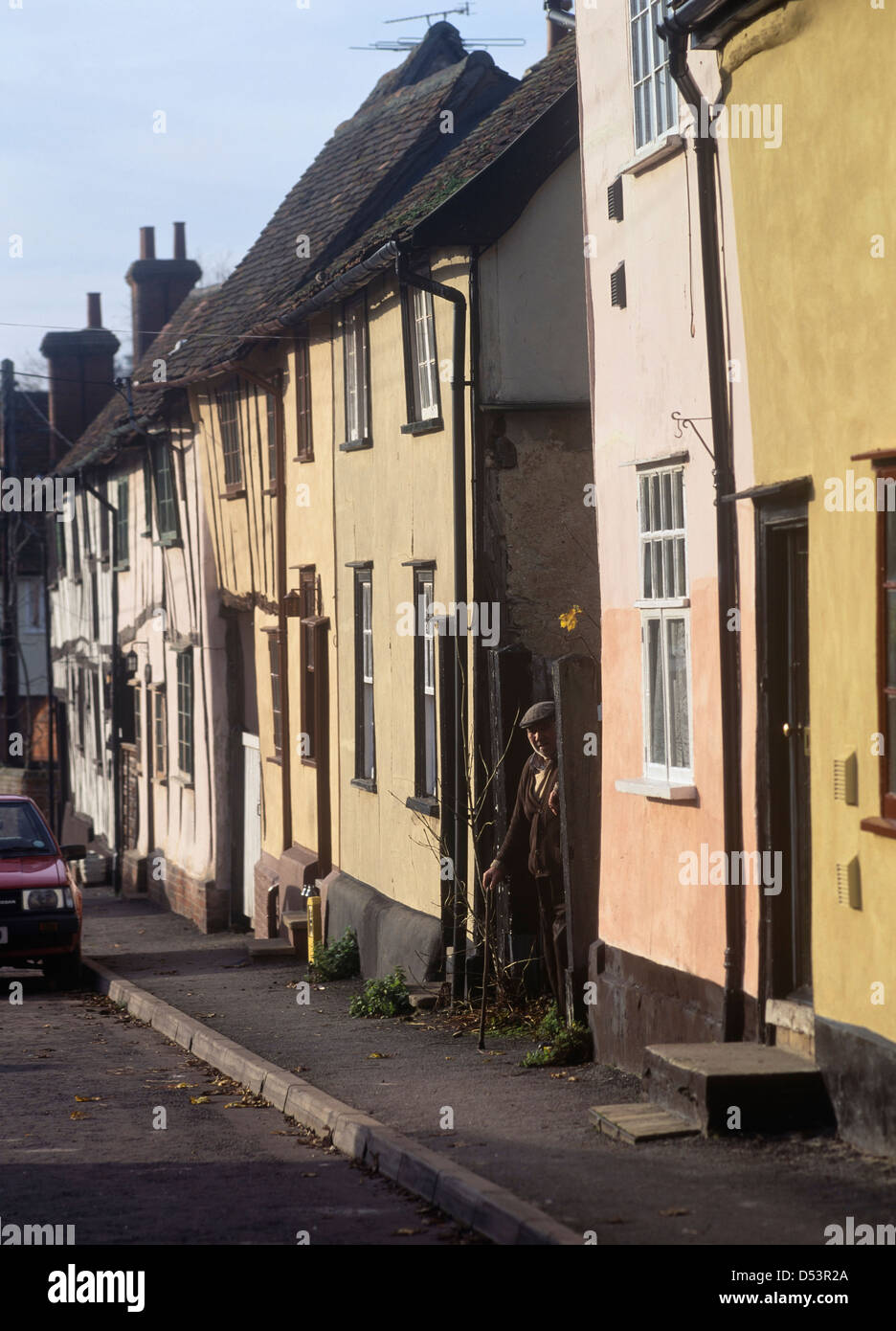 Pensioner standing outside his historic cottage, Bildeston, Suffolk ...
