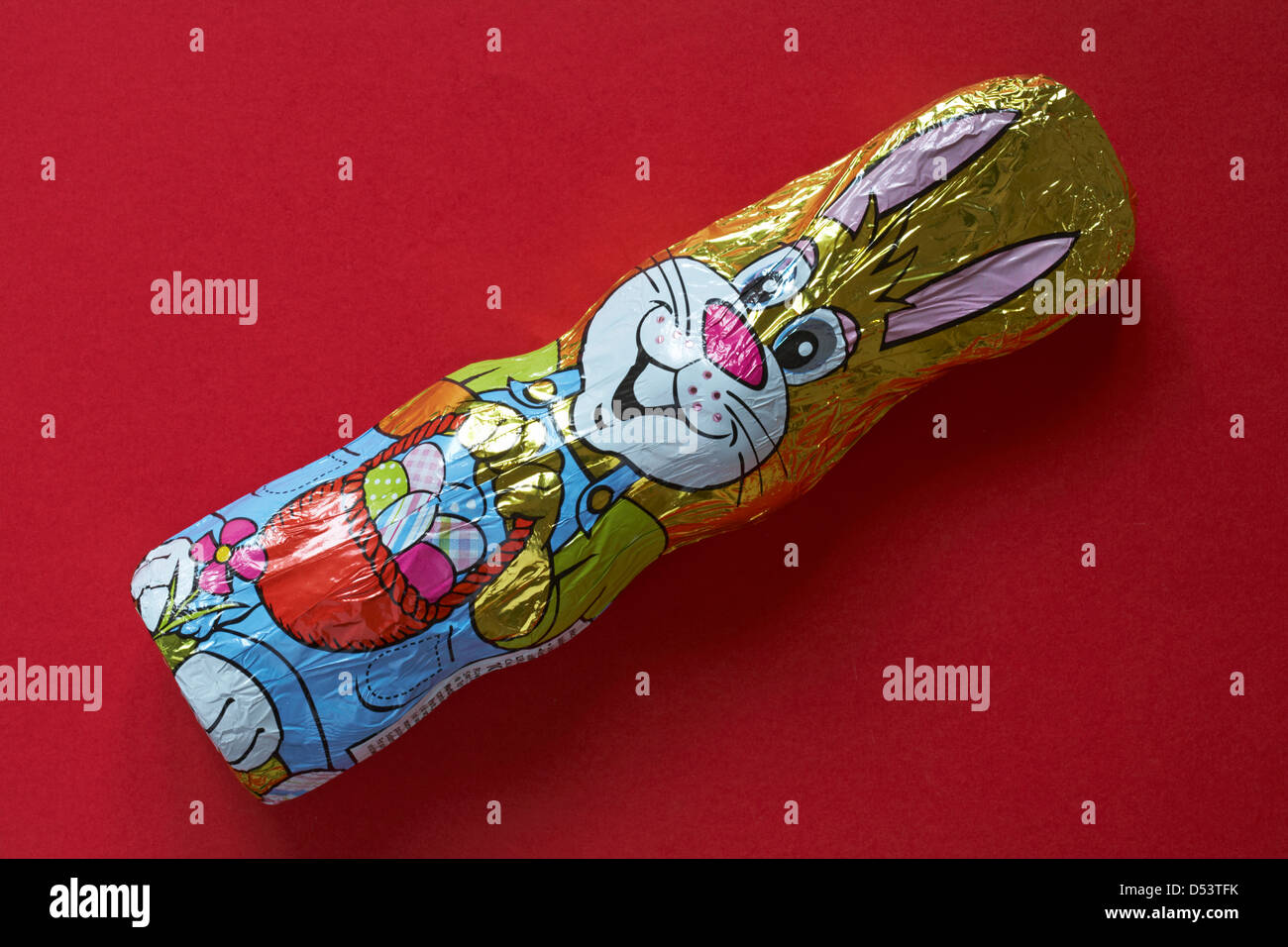 foil wrapped chocolate Easter bunny rabbit isolated on red background ...