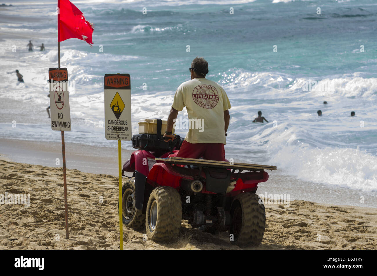 Lifeguard patrols Sunset Beach on ATV by caution signs Stock Photo - Alamy