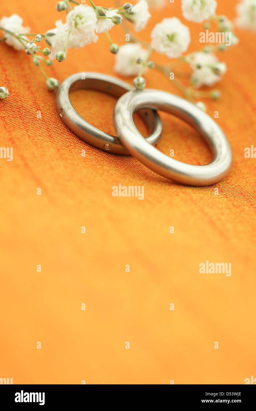 Wedding rings on orange silk with copy space Stock Photo - Alamy