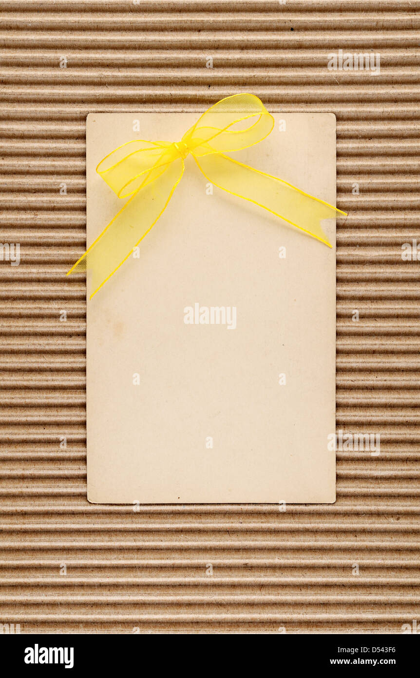 Old postcard with bow on corrugated cardboard Stock Photo - Alamy