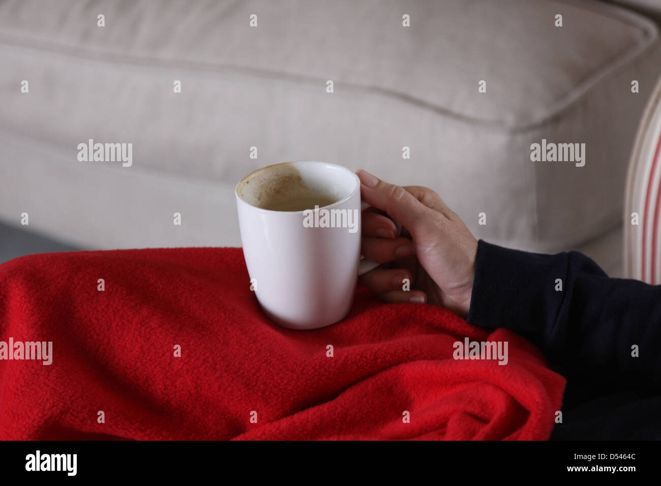 Hand held white coffee mug against red blanket background Stock Photo ...