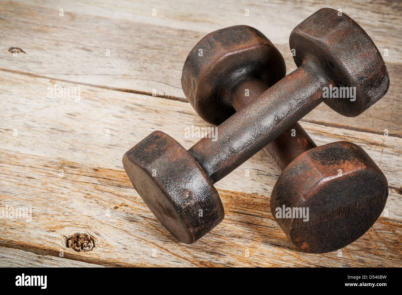 a pair of vintage iron rusty dumbbells on white painted barn wood ...