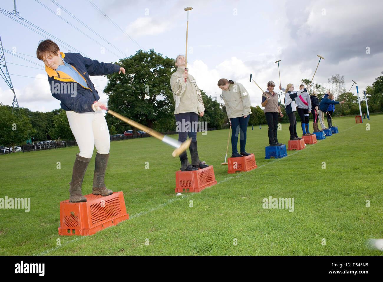 Women stood on boxes practice their polo swing during a lesson at Ascot ...