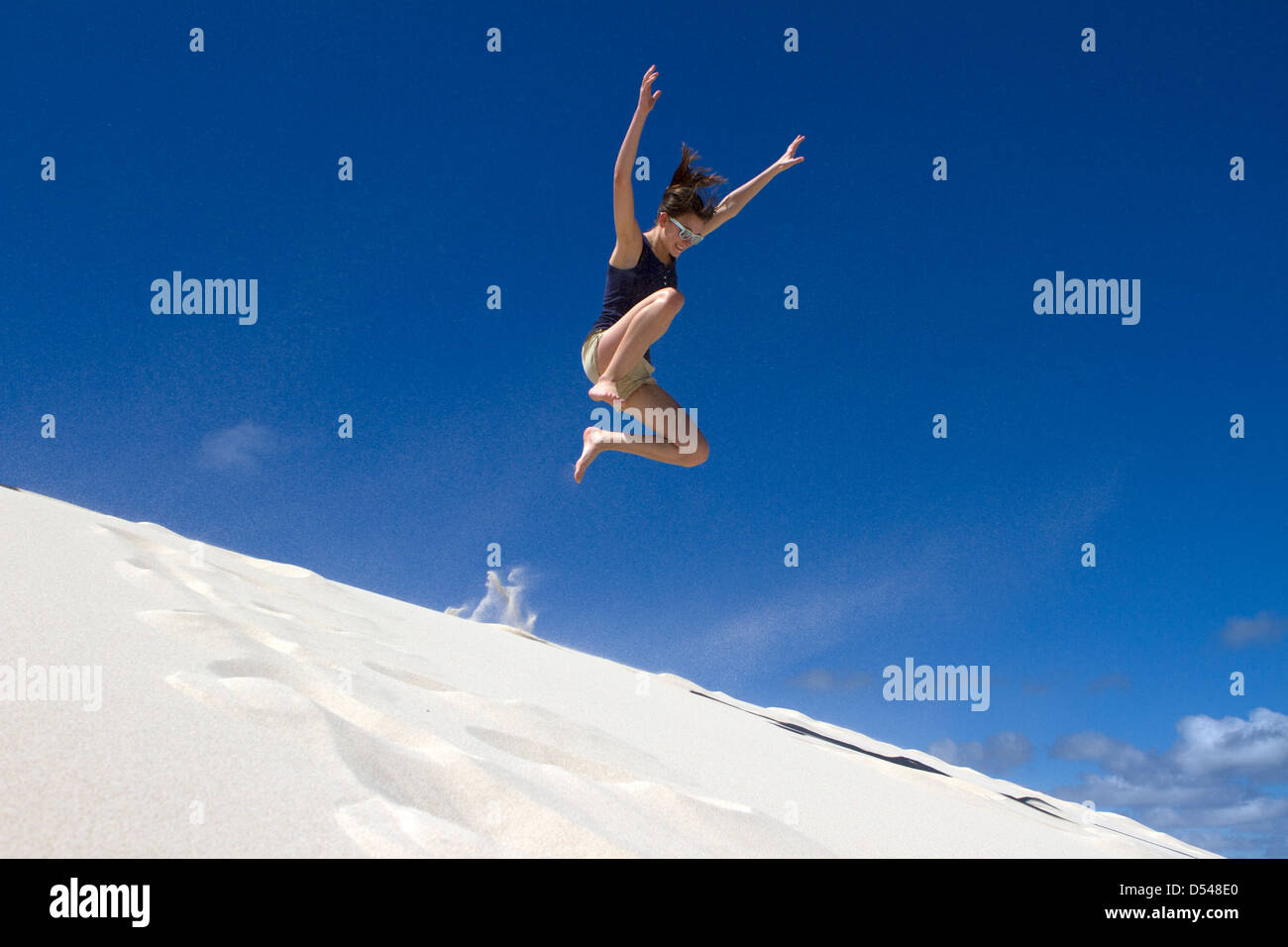 Girl jumping from a sand dune Stock Photo - Alamy