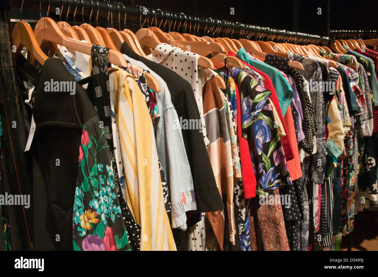 A long clothes rail packed with colurful patterned second hand vintage ...