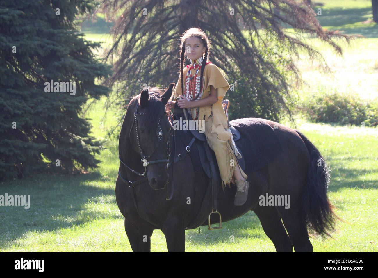 A young Native American Indian Lakota Sioux boy riding a black horse ...